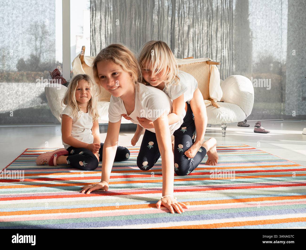 Three sisters in casual attire engaged in playful activity on a ...