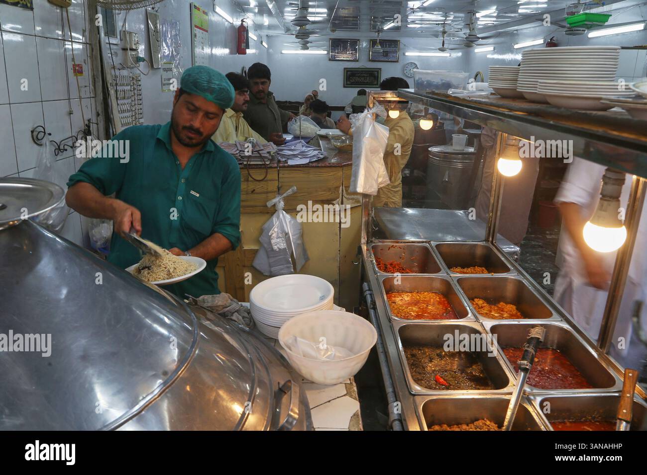 An Afghan cook works in an Afghan restaurant at a market in Peshawar ...