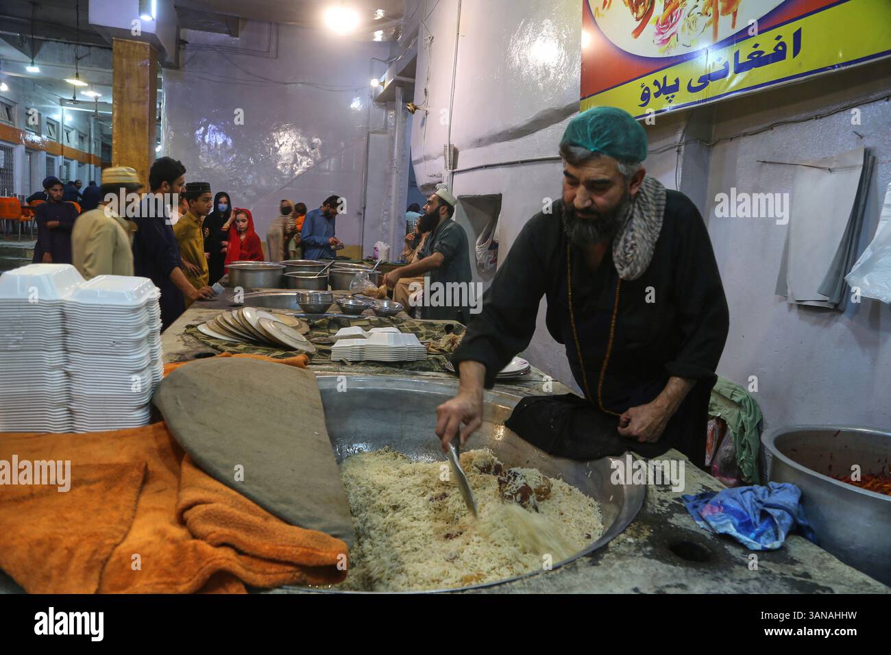 An Afghan cook, right, works in an Afghan restaurant at a market in ...