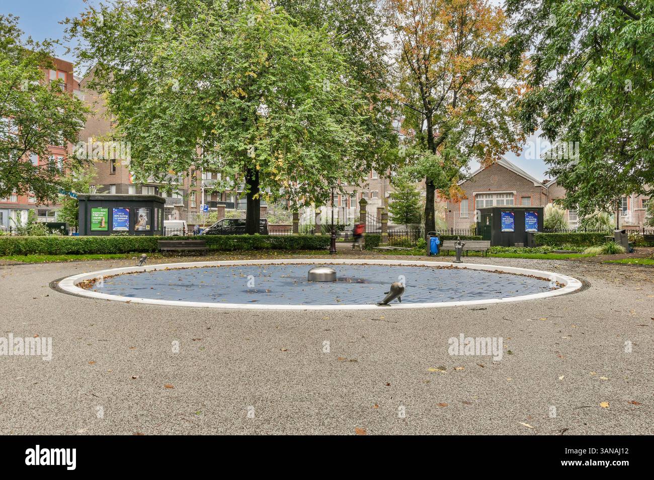 A tranquil park scene featuring a circular fountain at the center ...