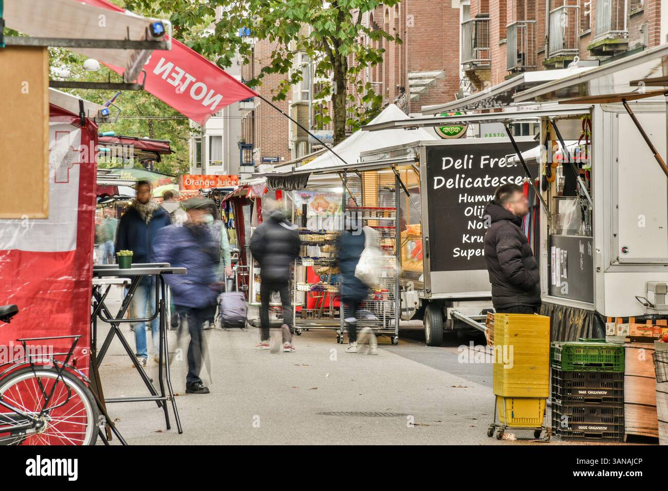 A vibrant street market showcasing food stalls with customers browsing ...
