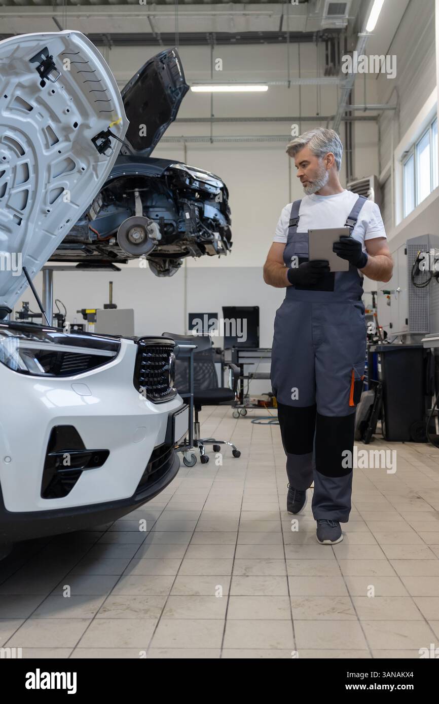 Technician in auto shop using advanced technology for inspection and ...