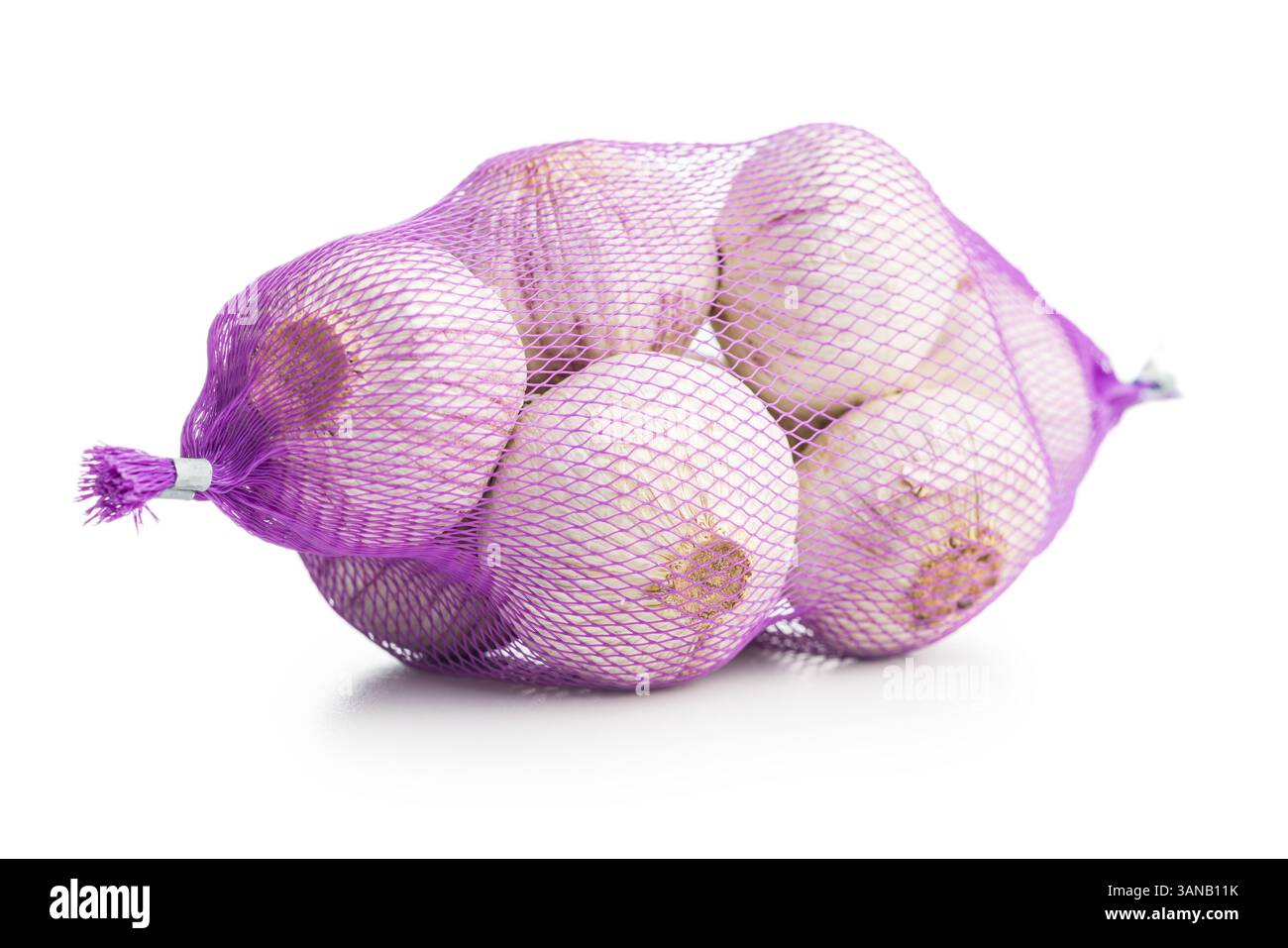 Single clove garlic wrapped in a net bag isolated on a white background ...