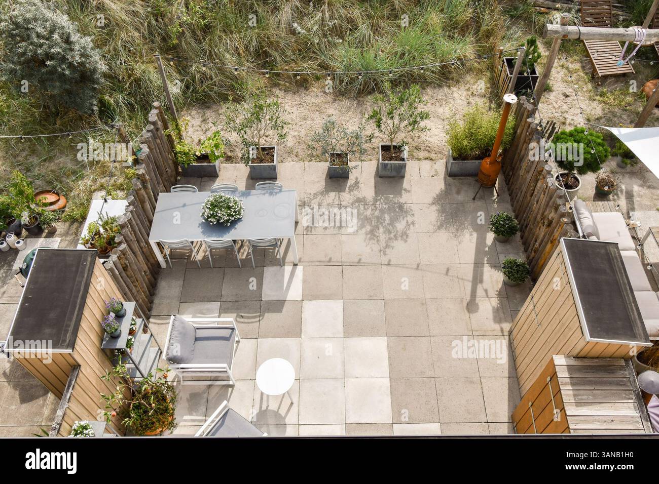 An aerial view of a modern outdoor patio featuring a table, chairs, and ...