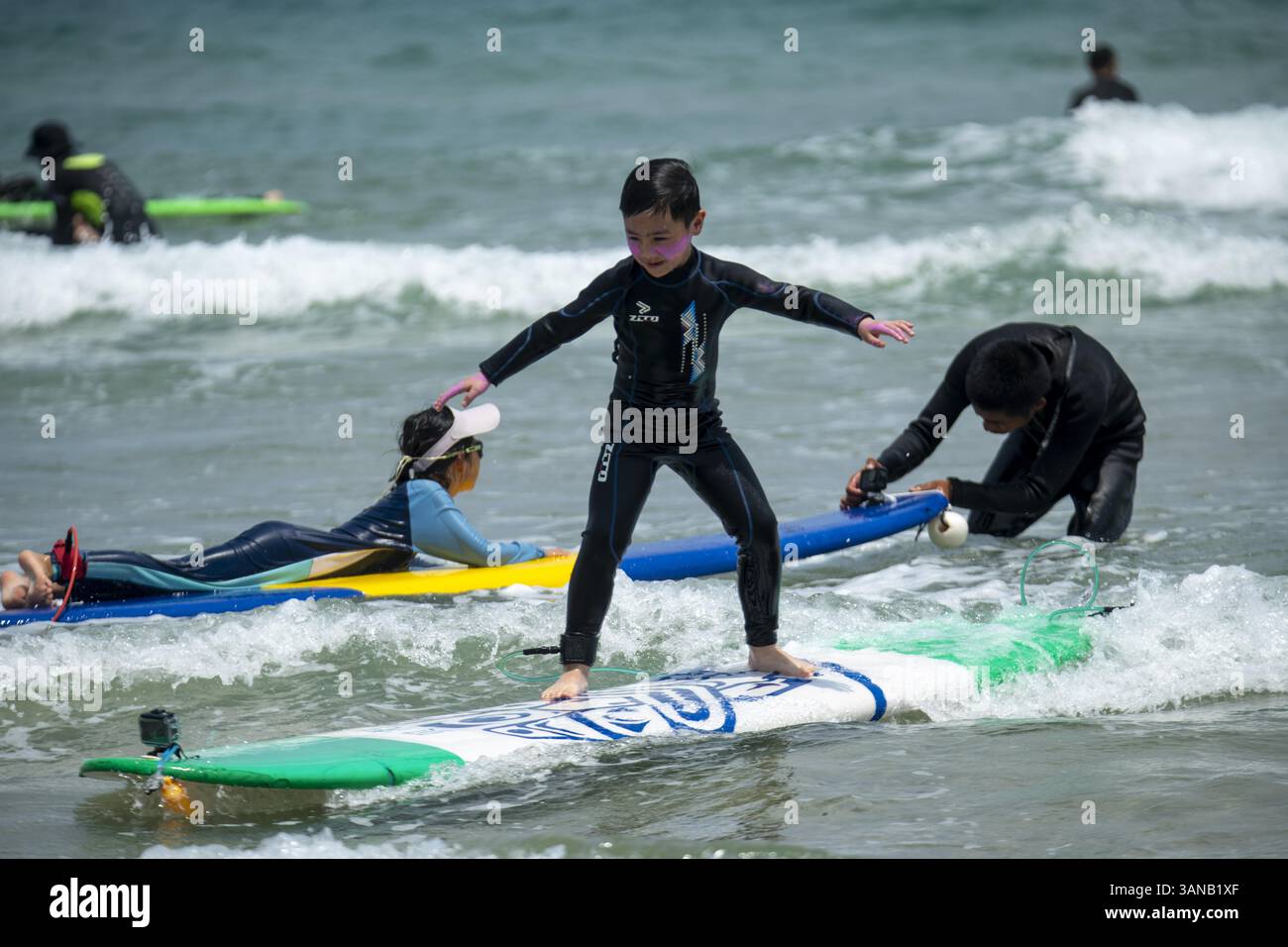 Tourists experience surfing at Riyue Bay in Wanning City, southernmost ...