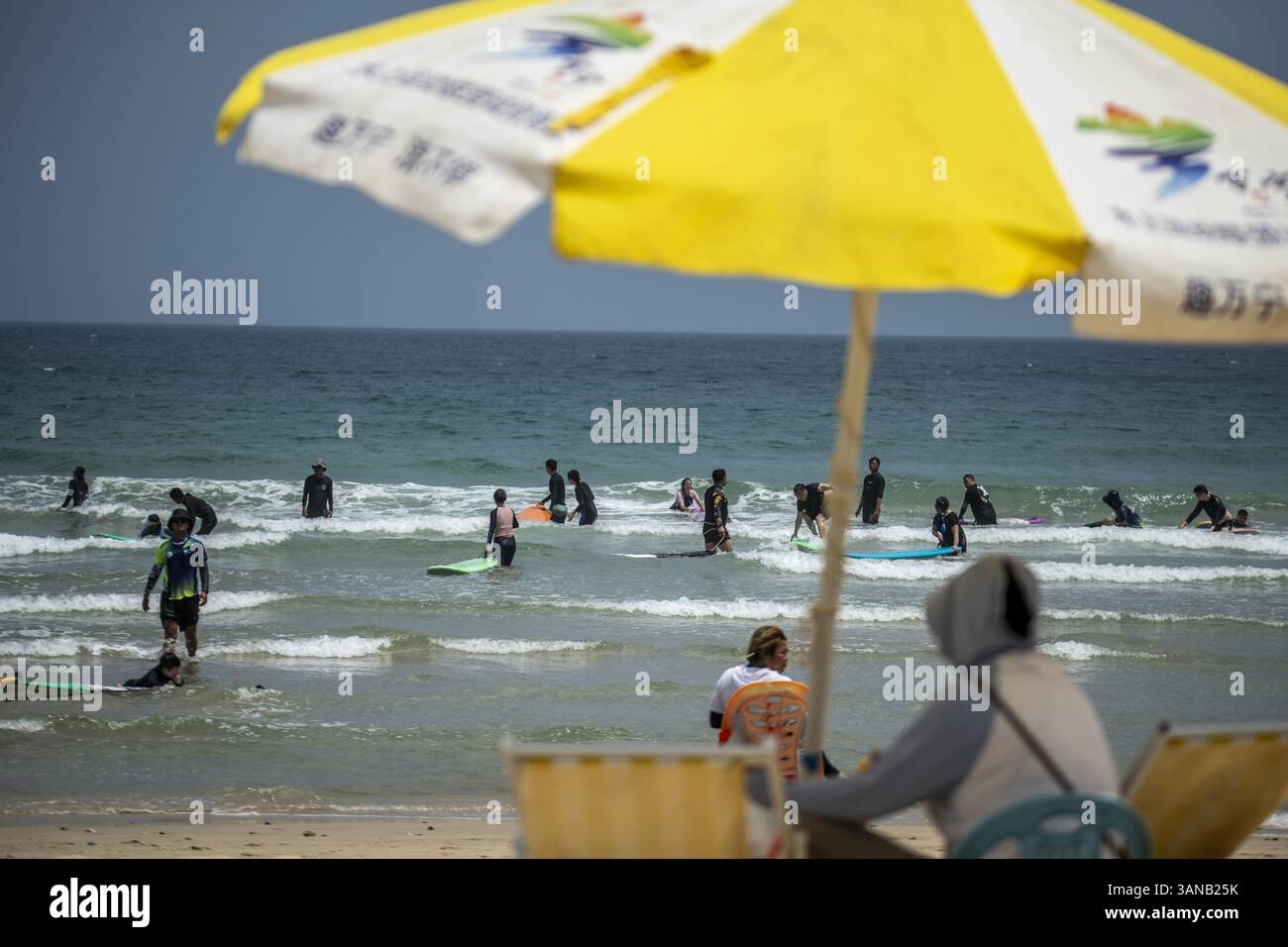 Tourists experience surfing at Riyue Bay in Wanning City, southernmost ...