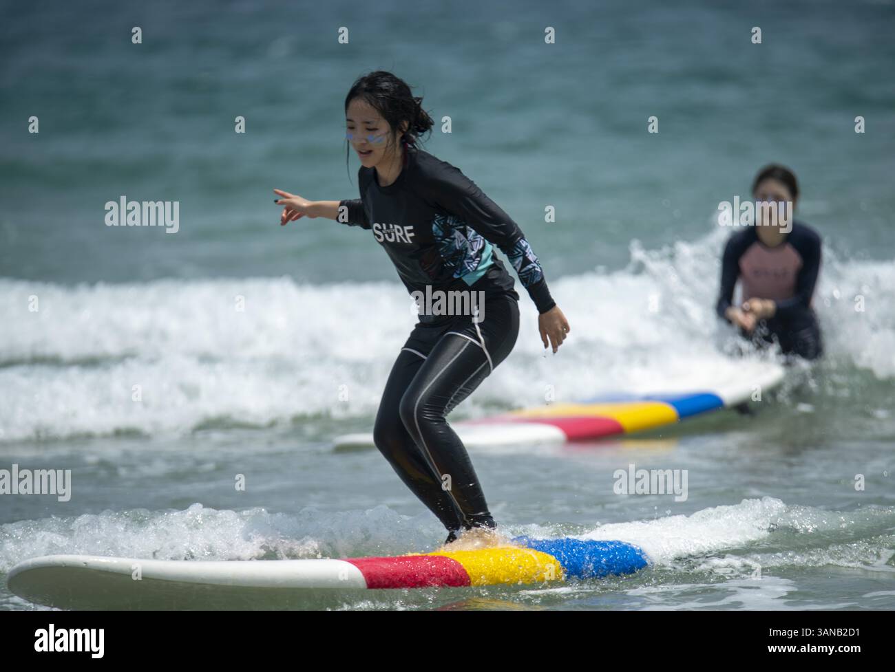 Tourists experience surfing at Riyue Bay in Wanning City, southernmost ...