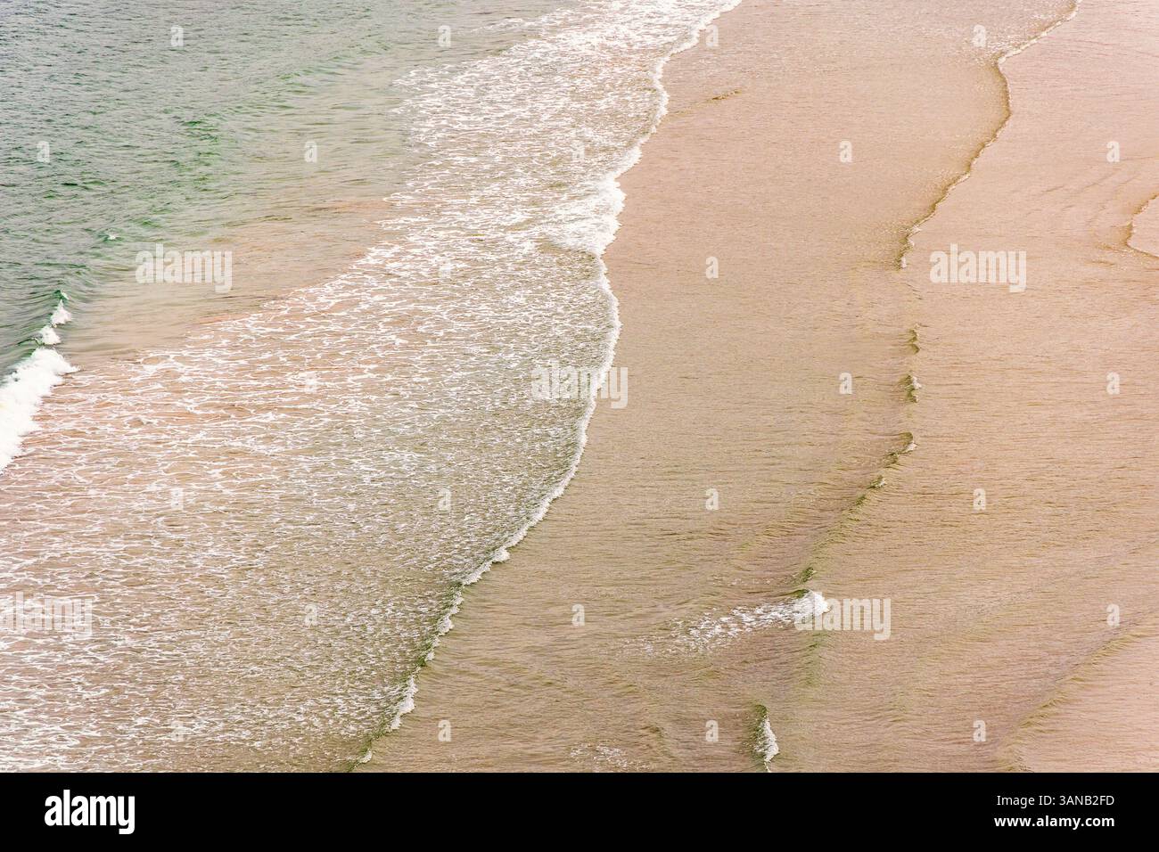 Aerial view at a sand beach with rolling sea waves Stock Photo - Alamy