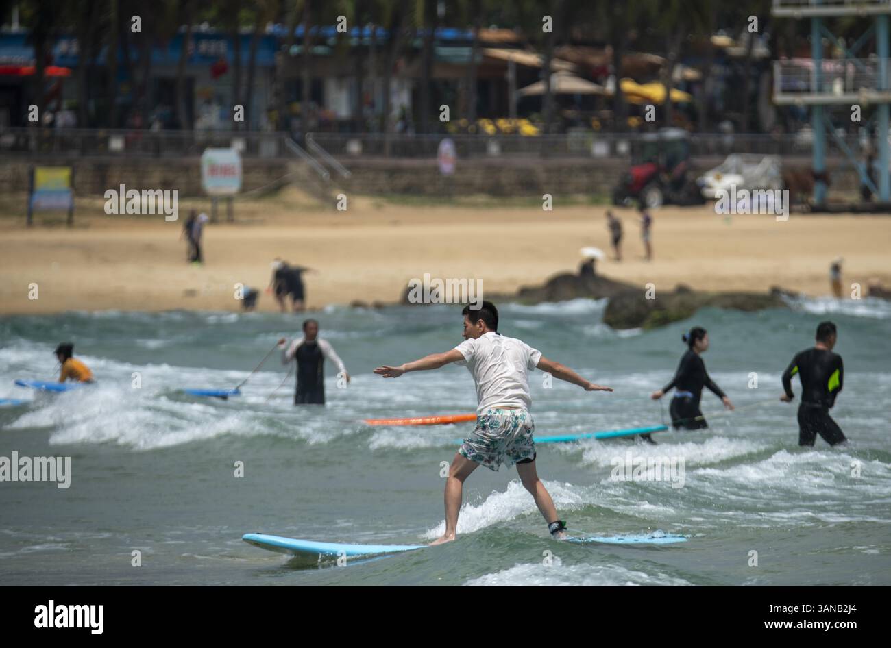 Tourists experience surfing at Riyue Bay in Wanning City, southernmost ...