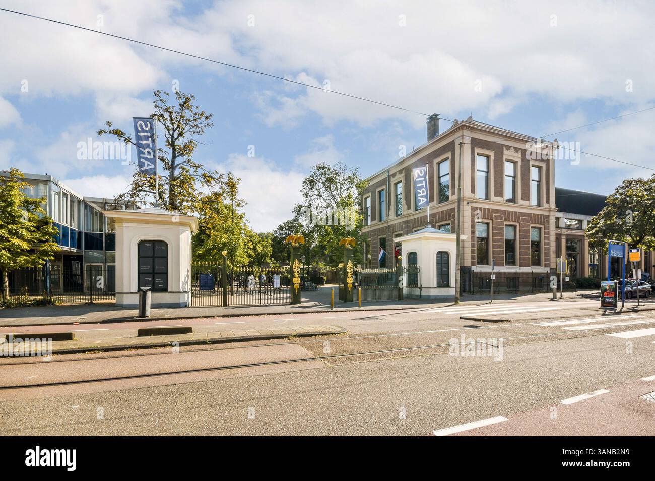 A striking modern historic building stands alongside manicured trees ...