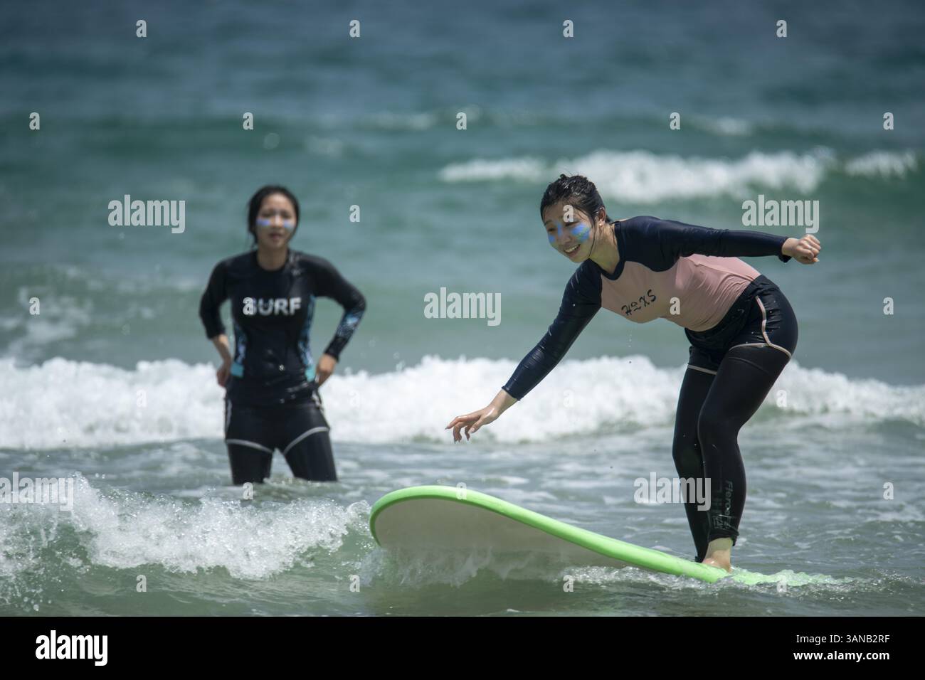 Tourists experience surfing at Riyue Bay in Wanning City, southernmost ...
