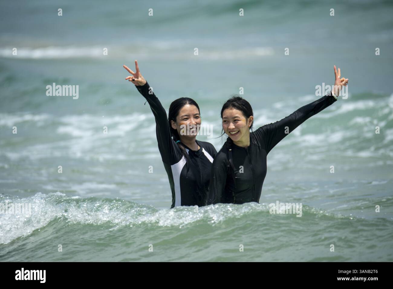 Tourists experience surfing at Riyue Bay in Wanning City, southernmost ...
