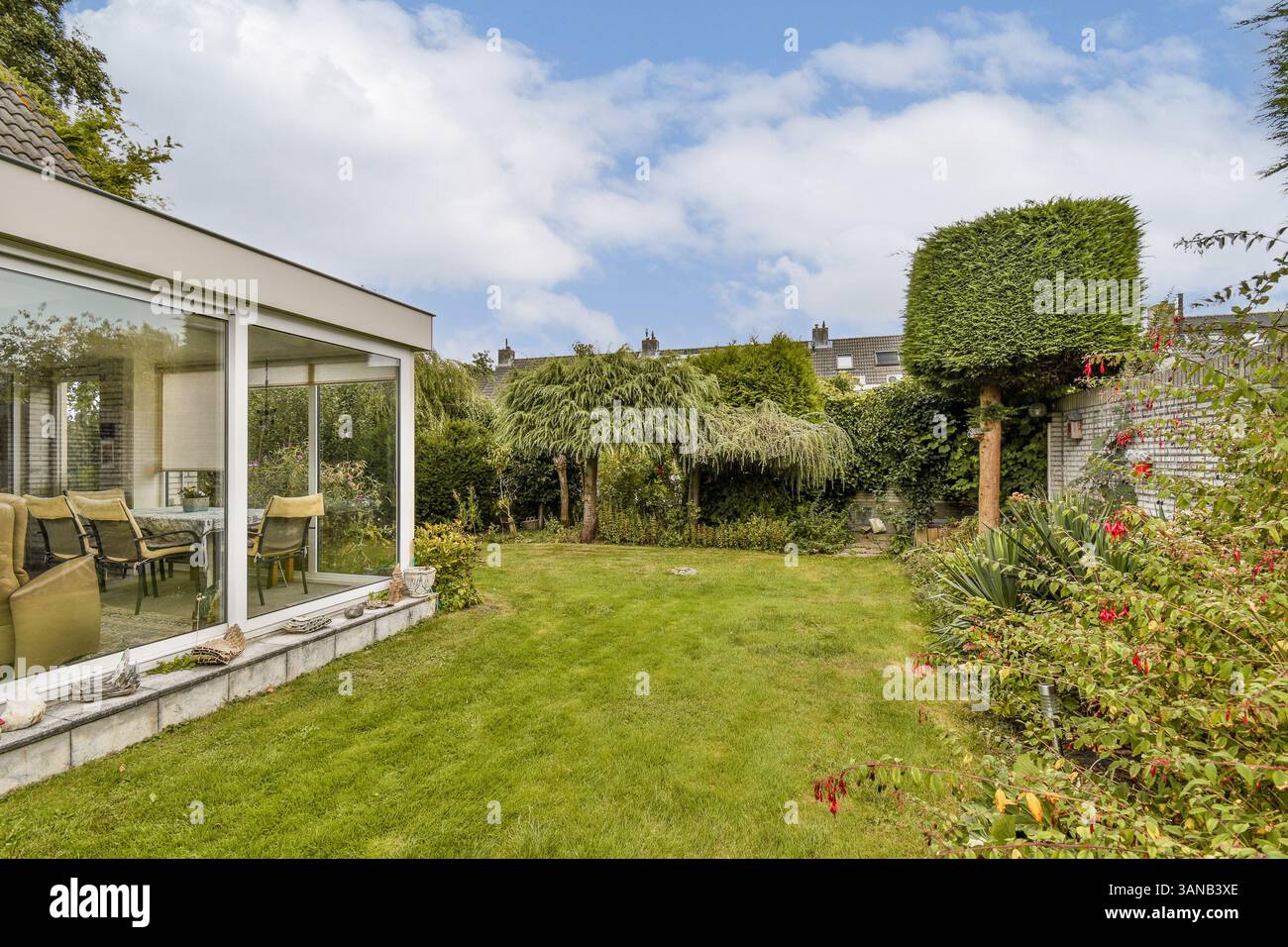 A serene garden featuring lush greenery, well-manicured bushes, and a ...