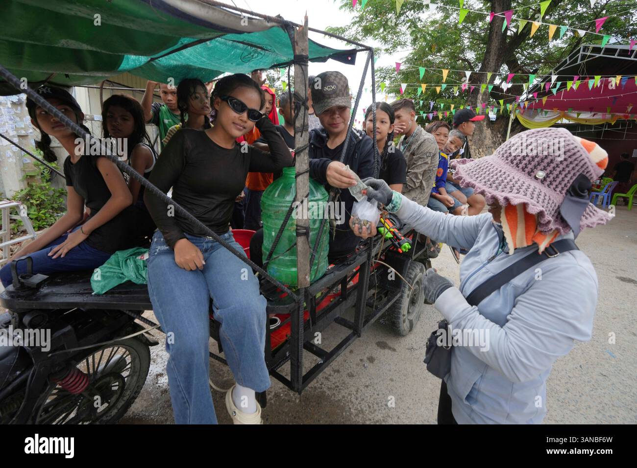Locals sit on a motor-cart as they head for cheering through the ...