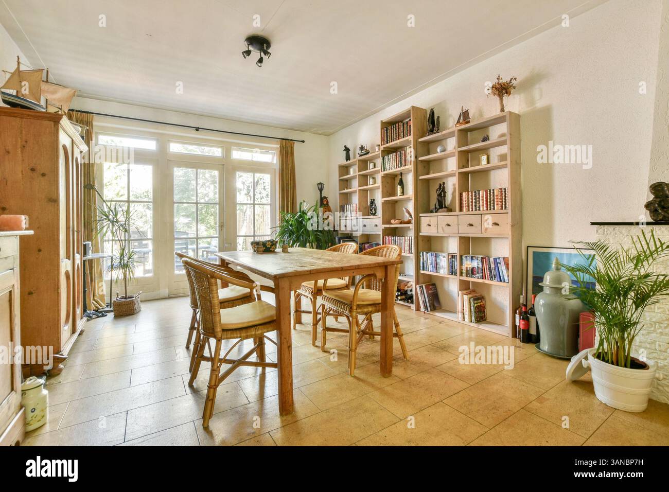 A charming dining space features a wooden table, shelves filled with ...