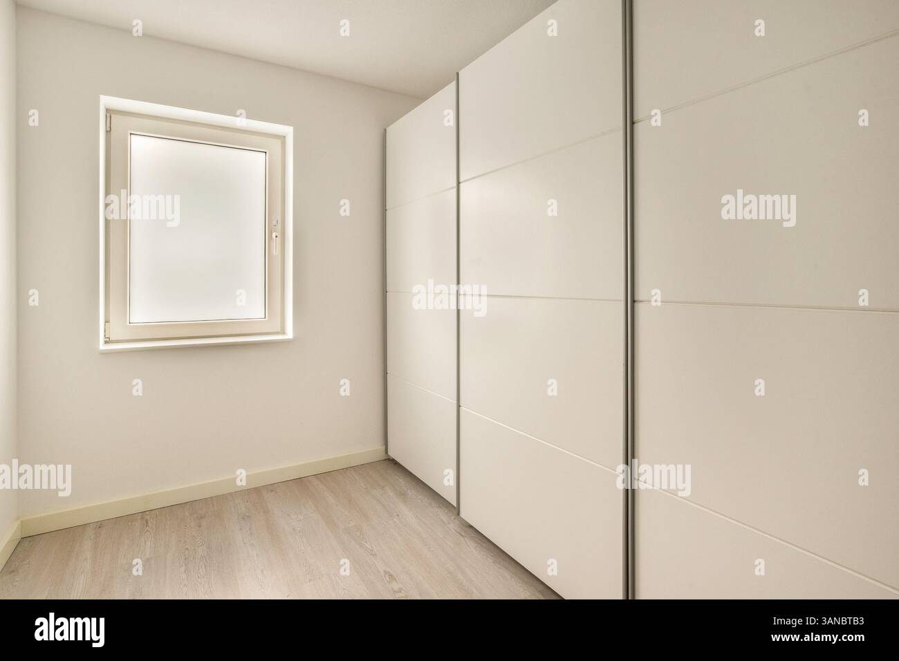 A contemporary room featuring a sleek wardrobe and a window allowing ...