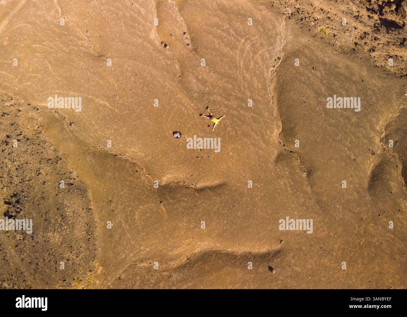 Aerial view of man lay down on rock formation soil, Spain Stock Photo ...