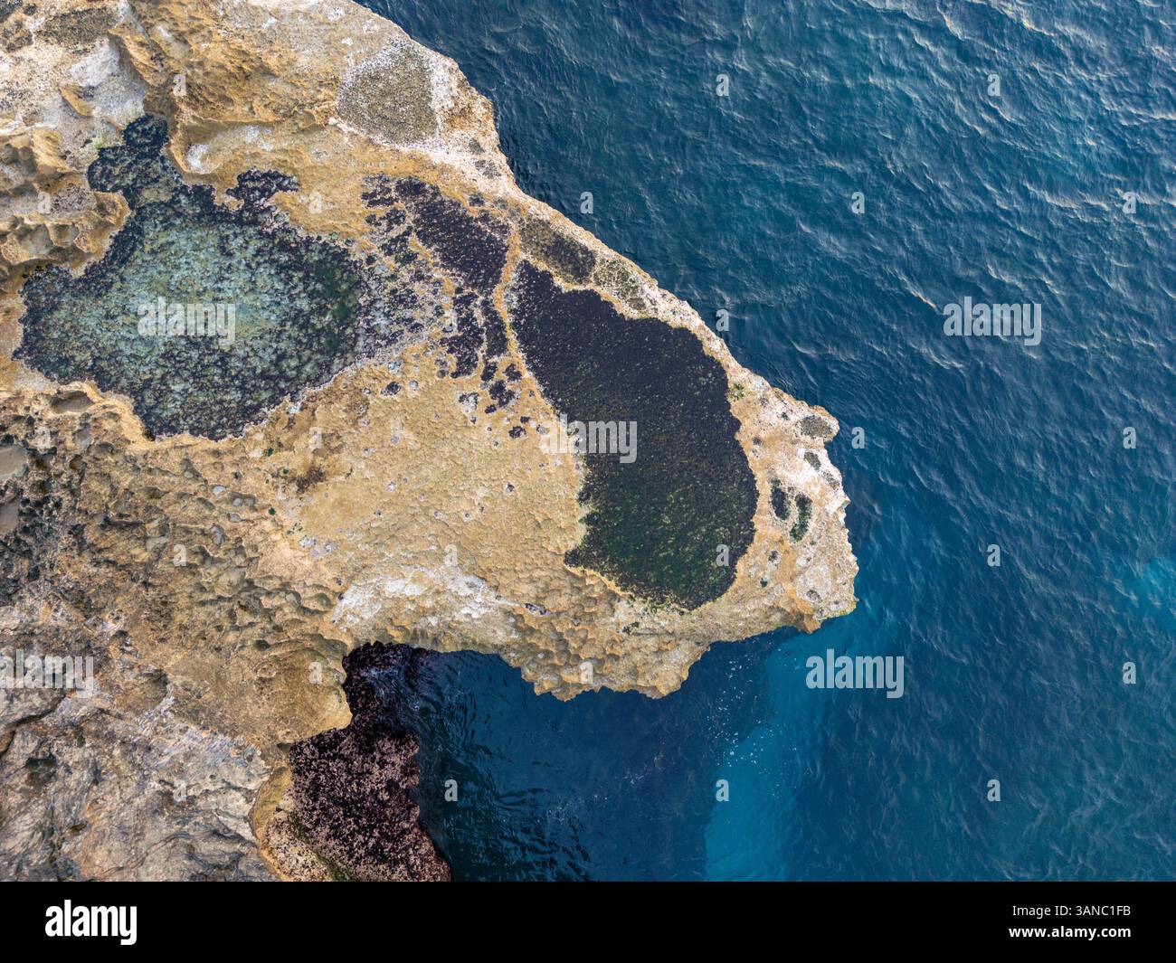 Aerial view of dramatic rock formations and pristine ocean along a ...