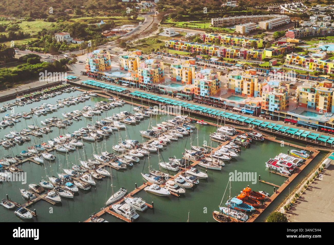 Aerial view of albufeira port with colorful buildings and docked boats ...