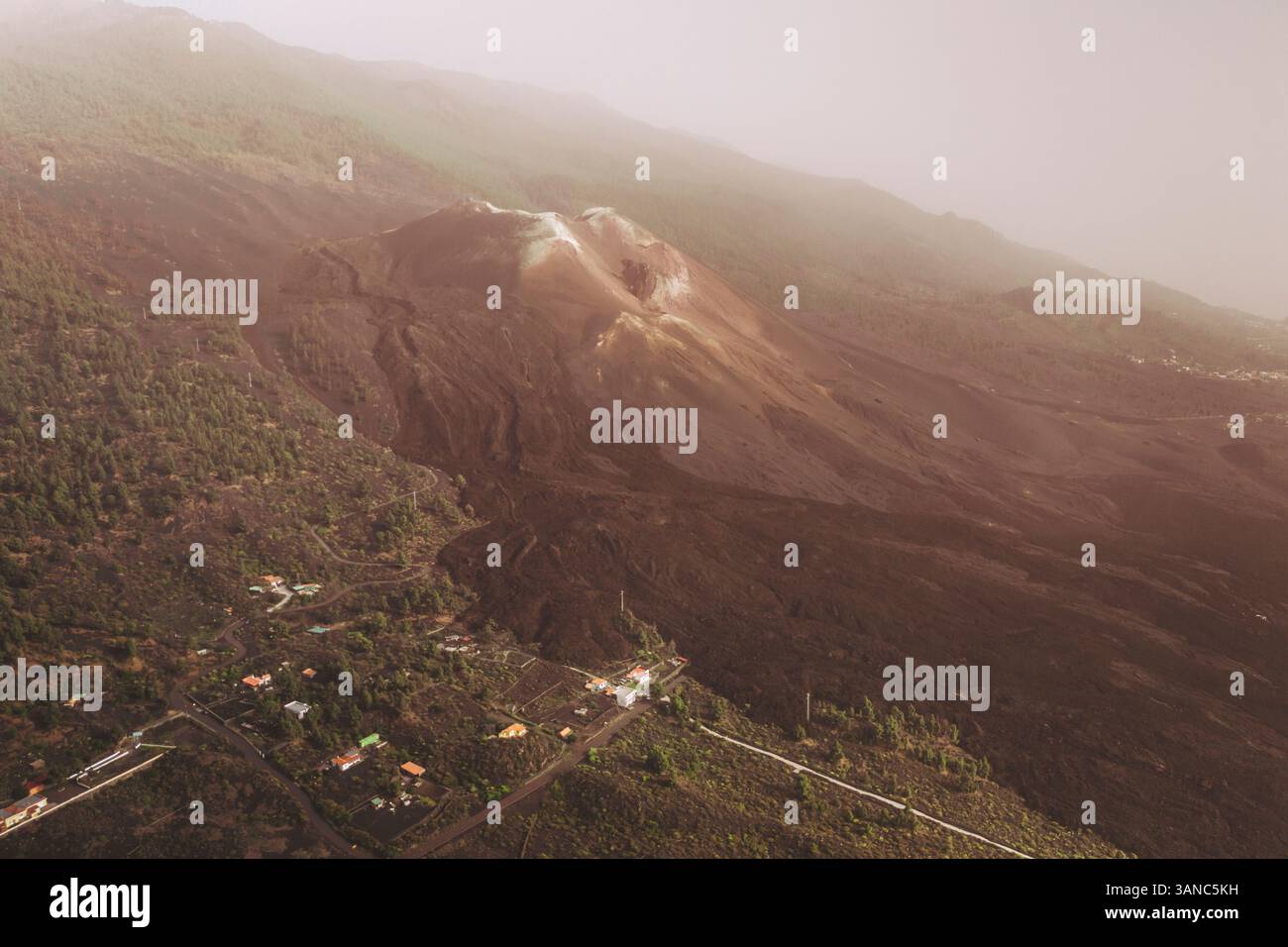 Aerial view of volcanic eruption at Volcan Tajogaite with buried houses ...