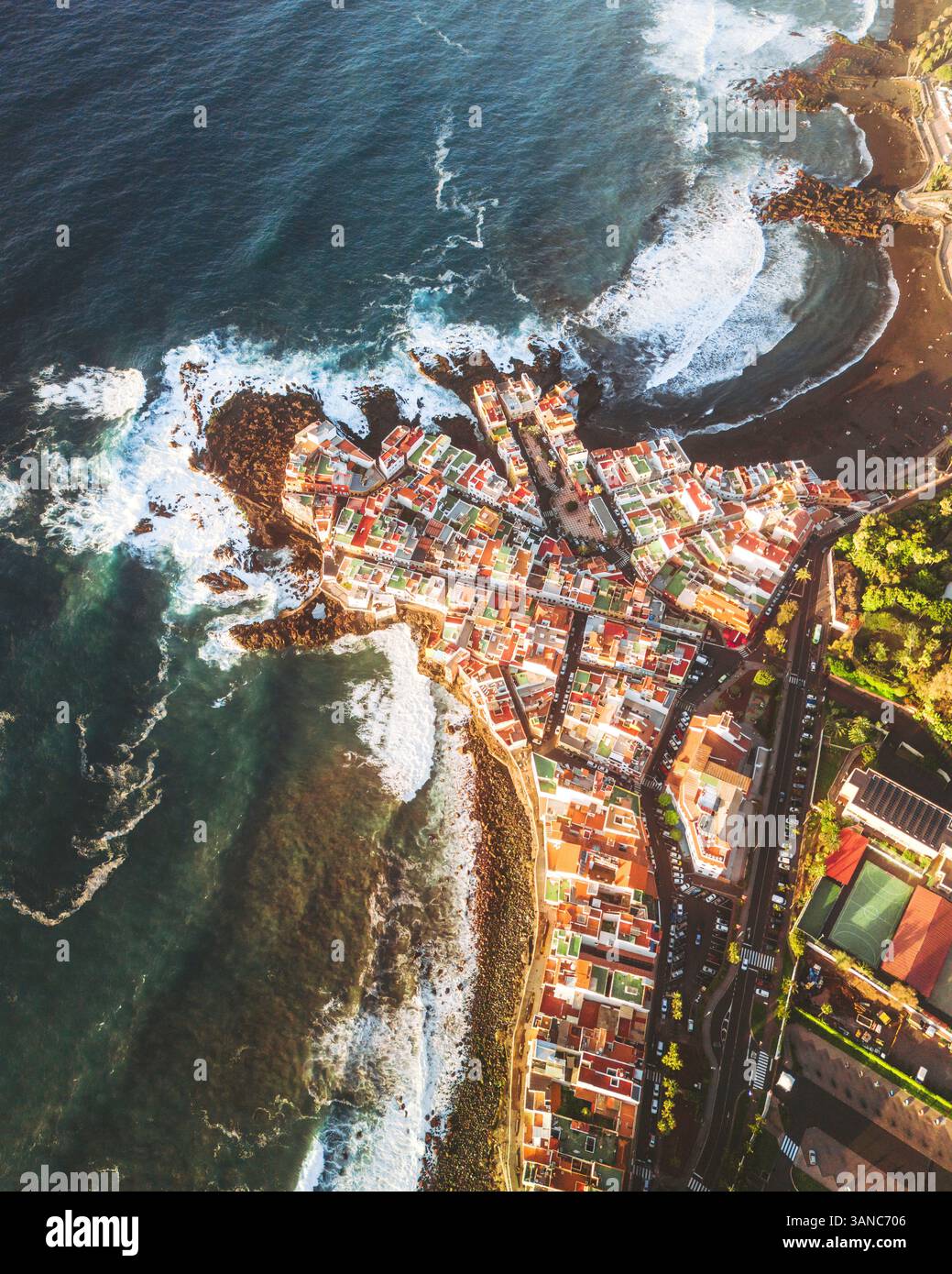 Aerial view of beautiful coastline with ocean waves and urban buildings ...