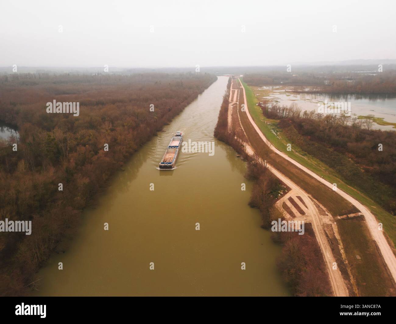 Aerial view of serene Seine River Retention Basin with barges and lush ...