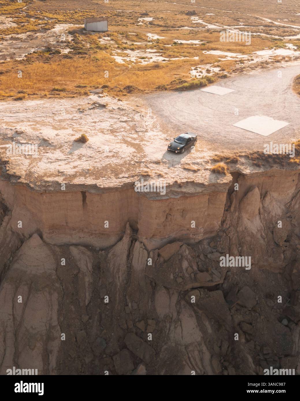 Aerial view of barren rock formations and a scenic road with a Japanese ...