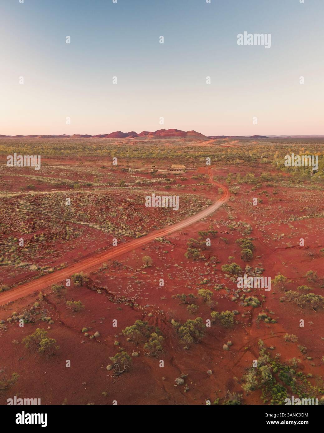 Aerial view of the arid desert landscape with a dirt road and expansive ...
