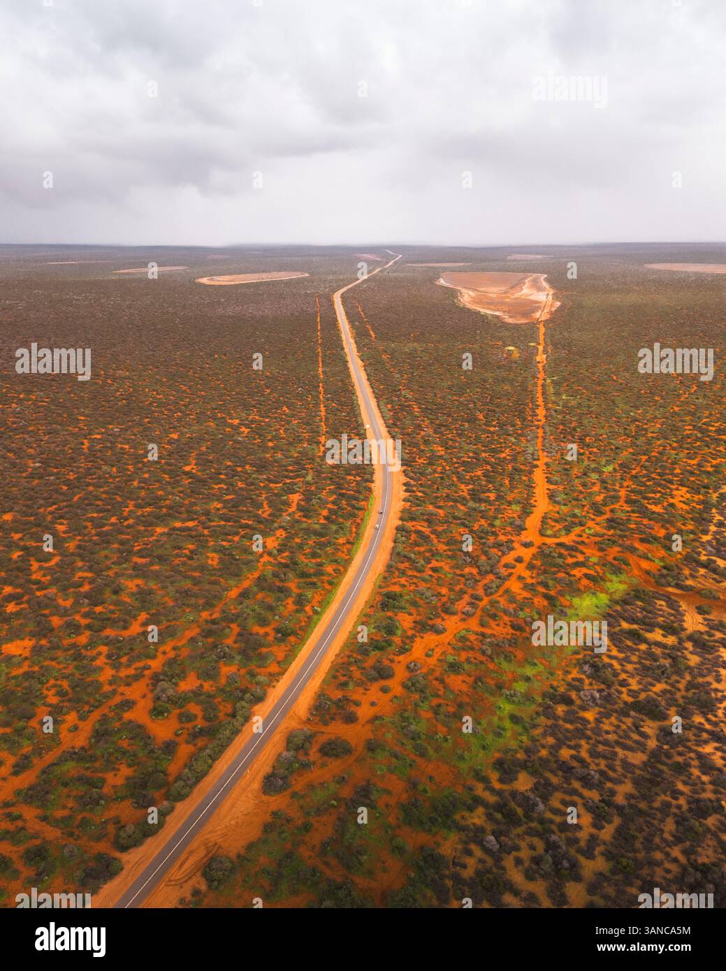 Aerial view of arid desert landscape with a winding road and sparse ...