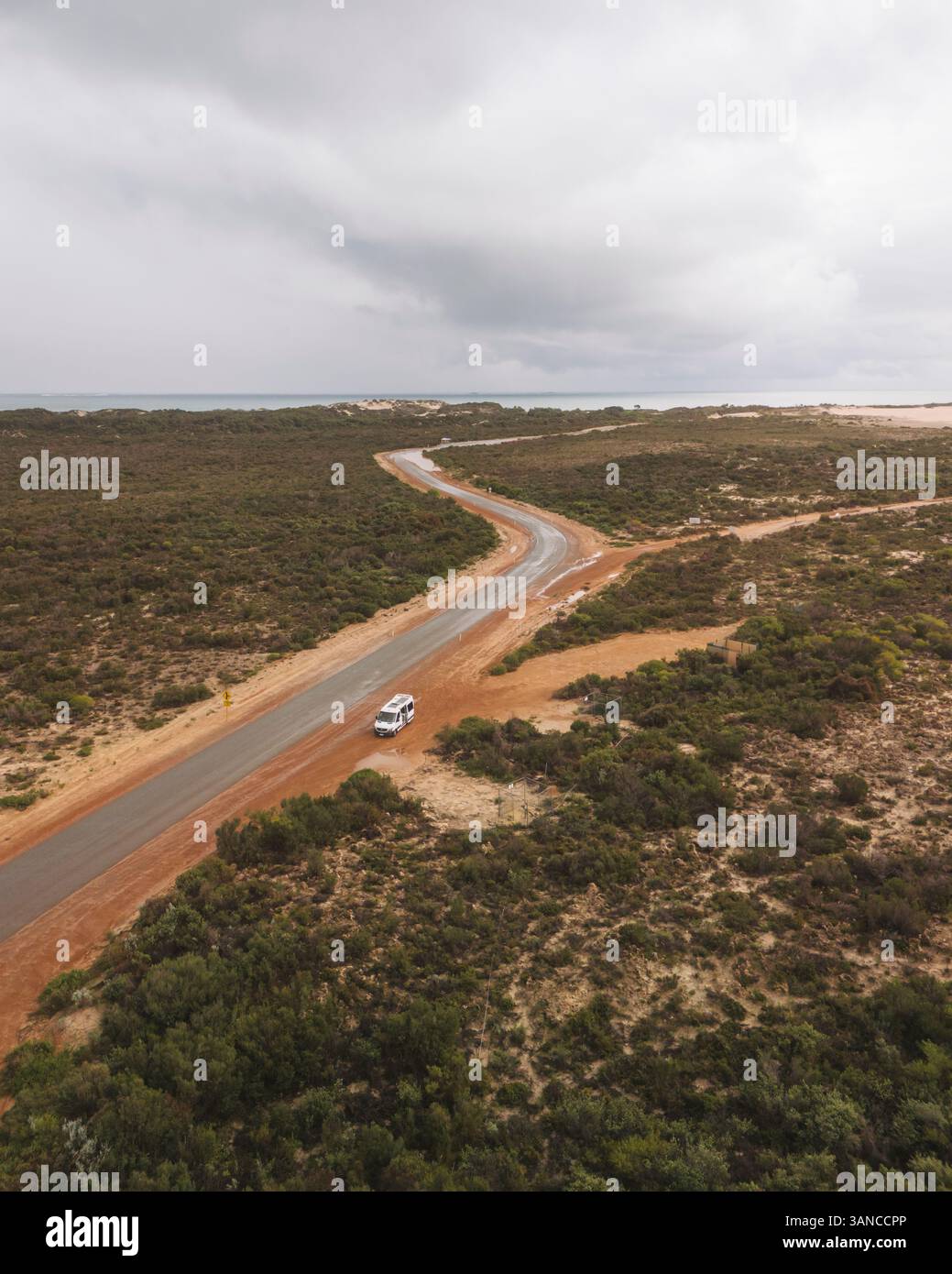 Aerial view of sandy cape with a winding road and serene bushland, Baie ...