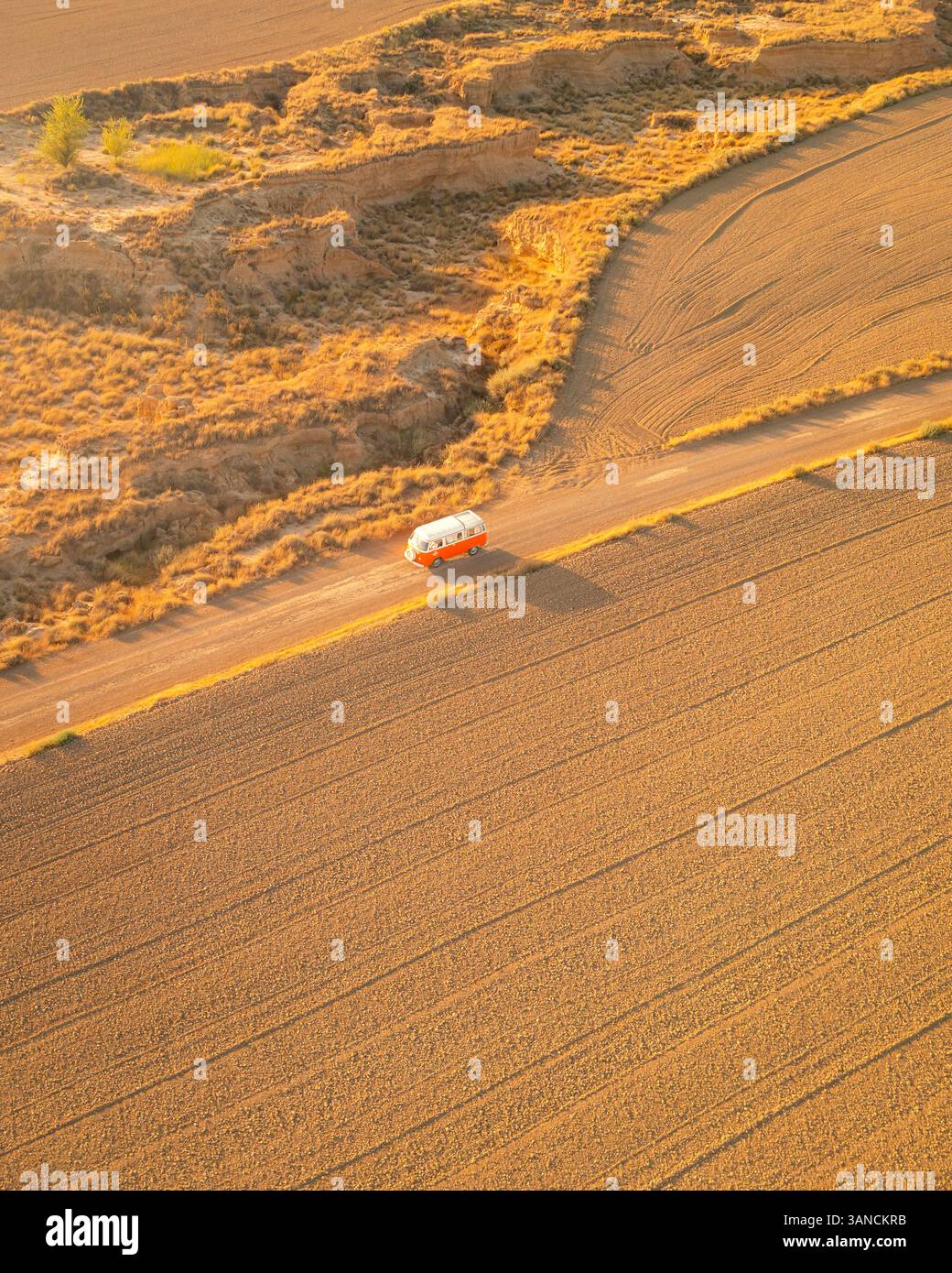 Aerial view of a vintage orange campervan, in the Bardenas Reales ...