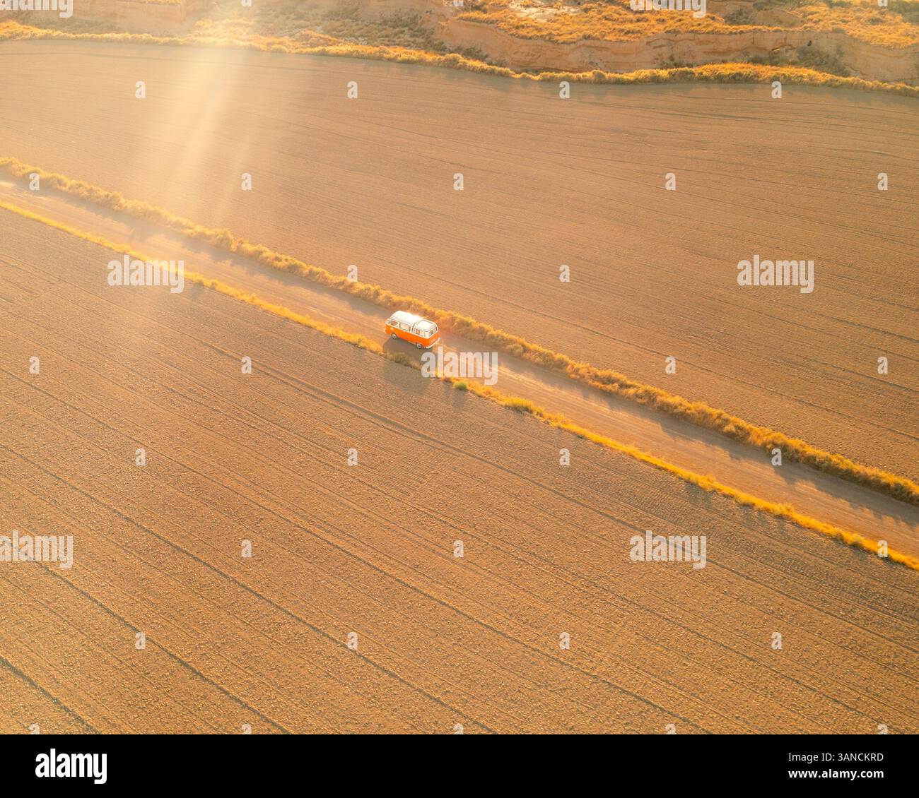 Aerial view of a vintage orange campervan, in the Bardenas Reales ...
