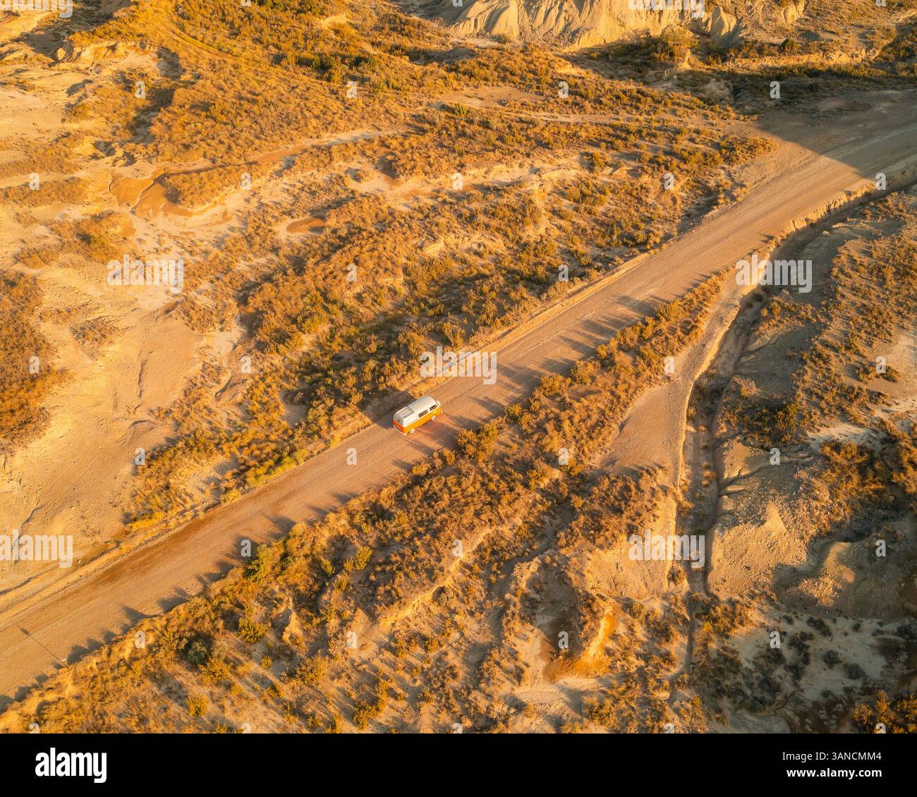 Aerial view of a vintage orange campervan, in the Bardenas Reales ...