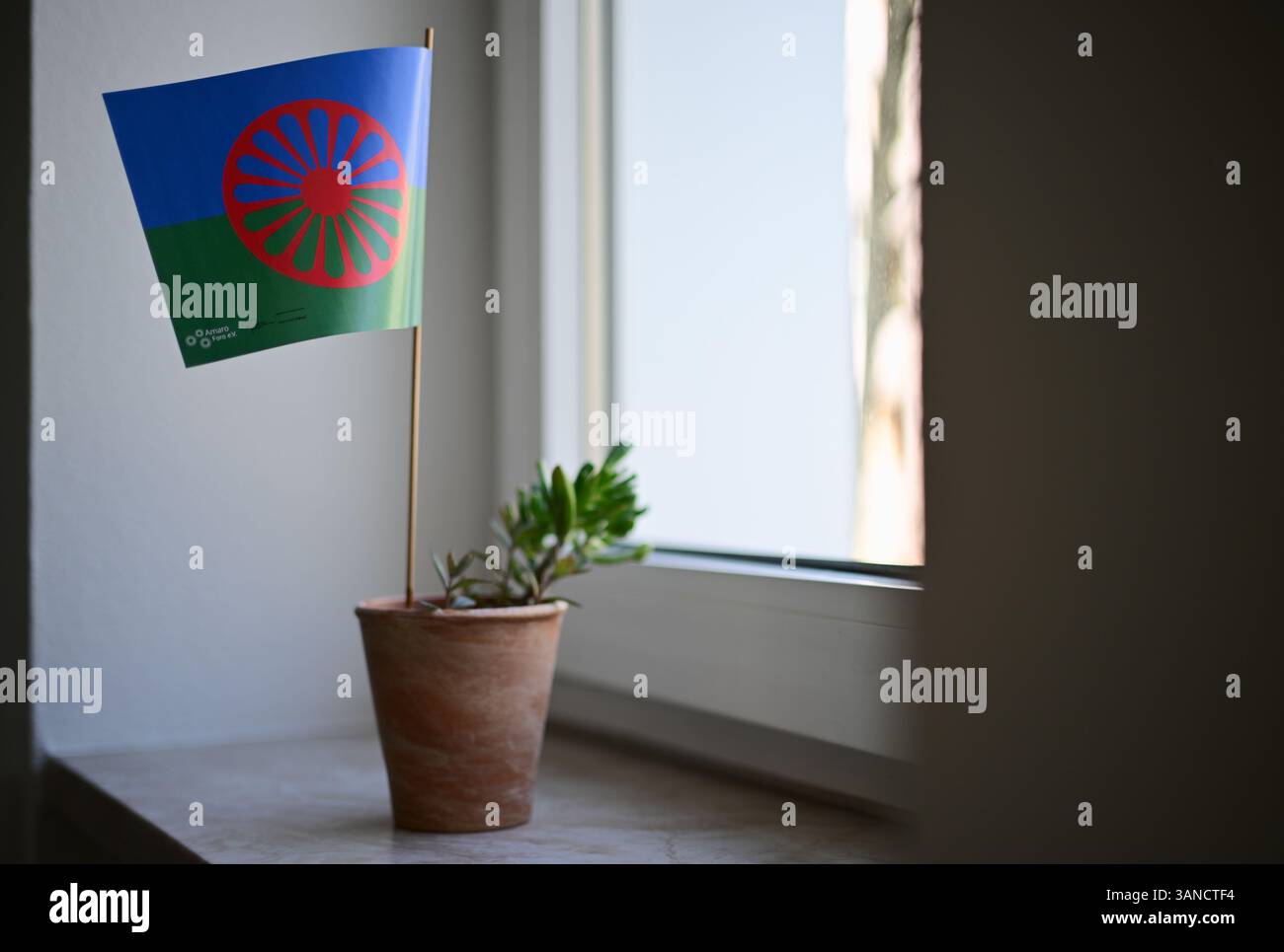 Berlin, Germany. 15th Apr, 2025. A Rom*nja flag is stuck in a flower ...