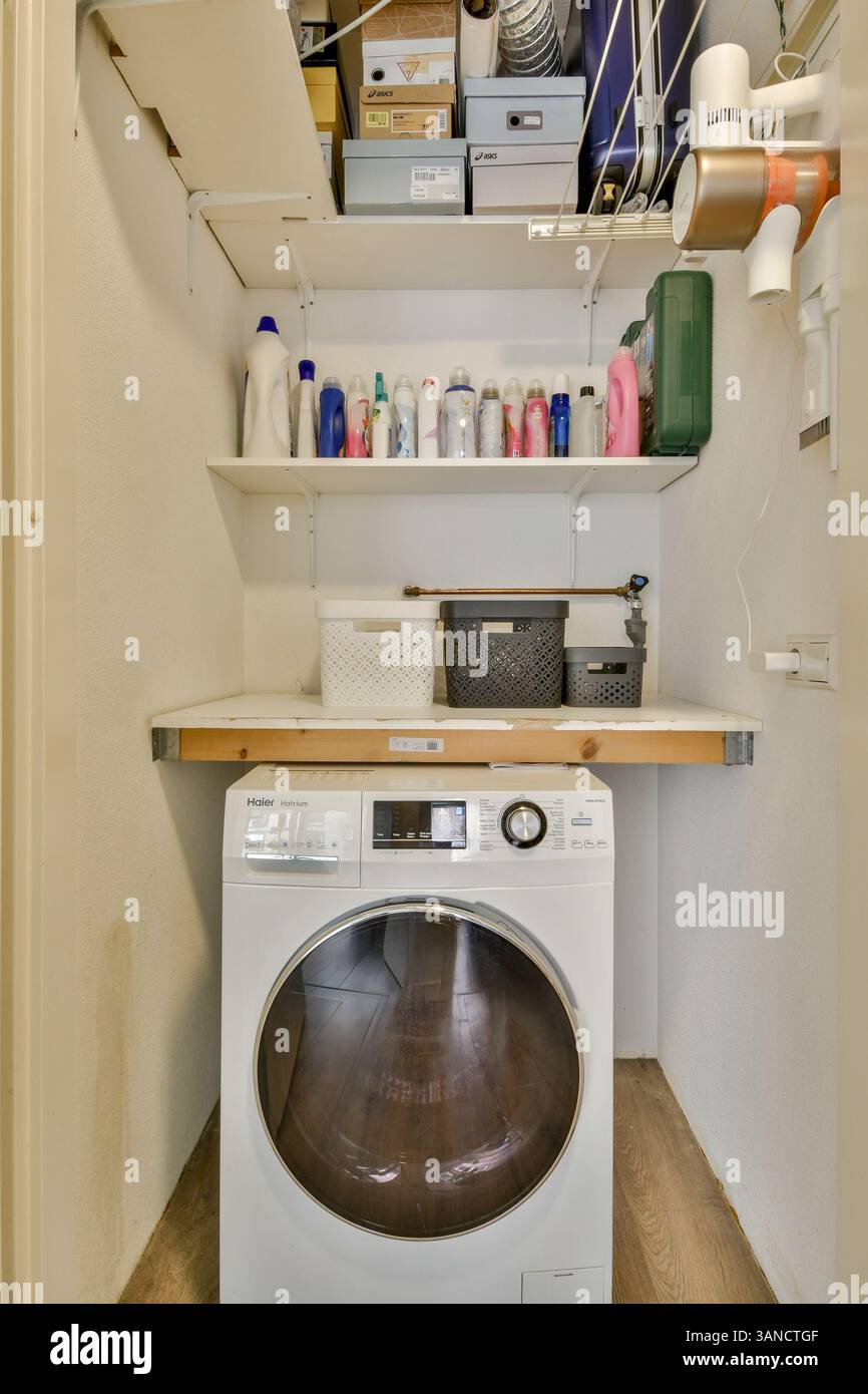 A well-organized laundry space featuring a washing machine, neatly ...