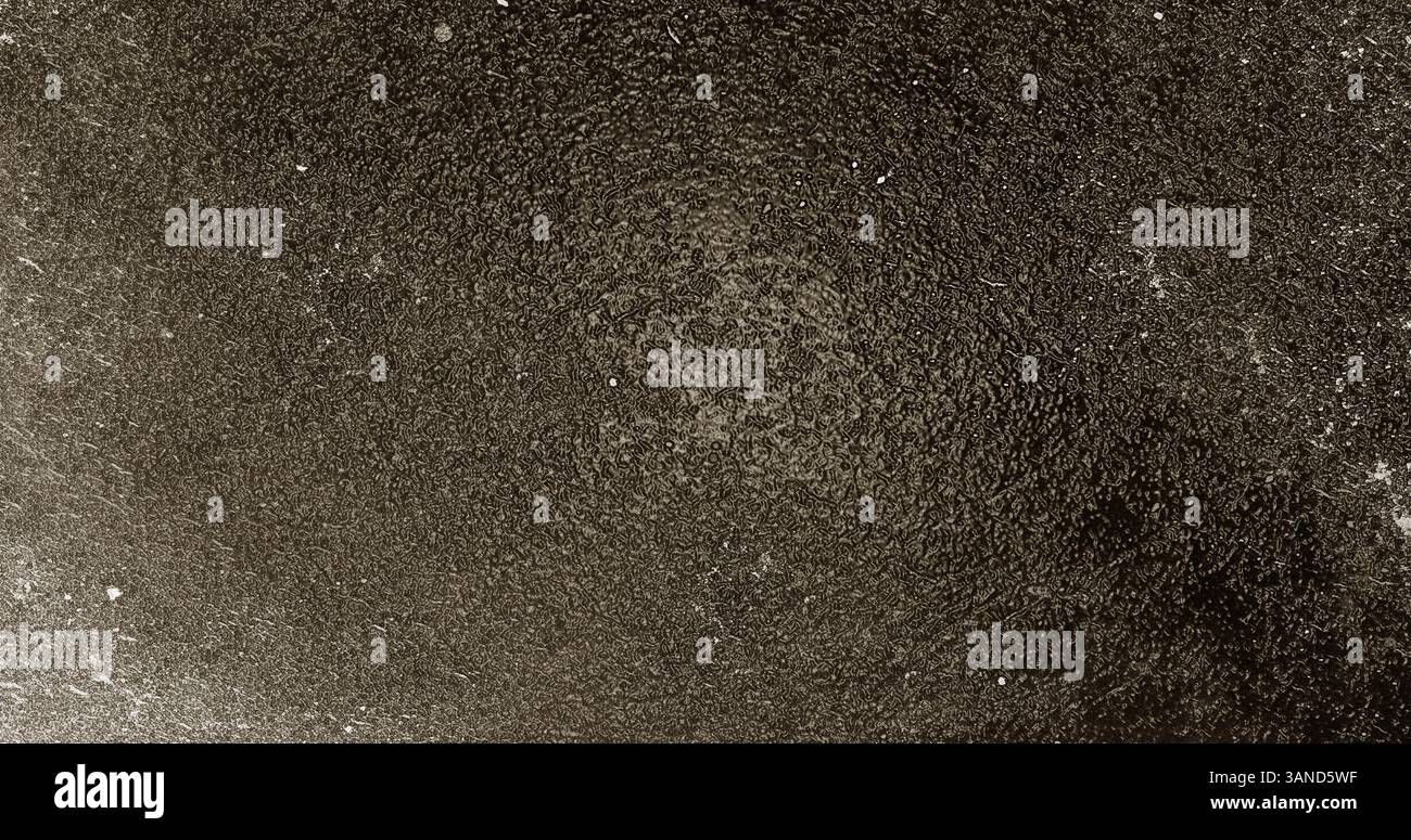 Dark grainy texture creating abstract background with vignette effect ...