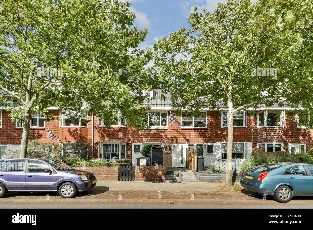 A picturesque view of urban row houses featuring lush green trees along ...