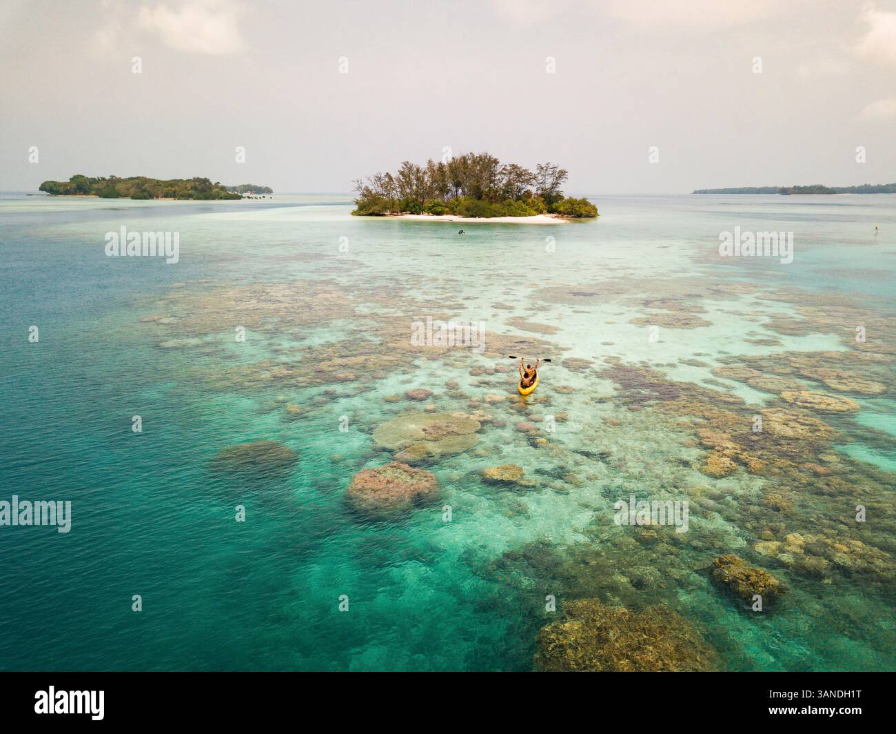 Aerial view of two-man paddling near Pulau Macan Island, Indonesia ...