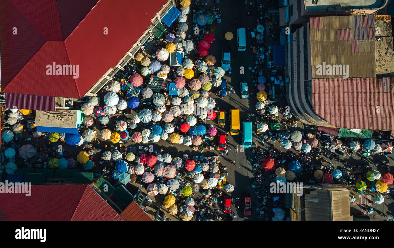 Aerial view of a bustling street market with colorful umbrellas and ...