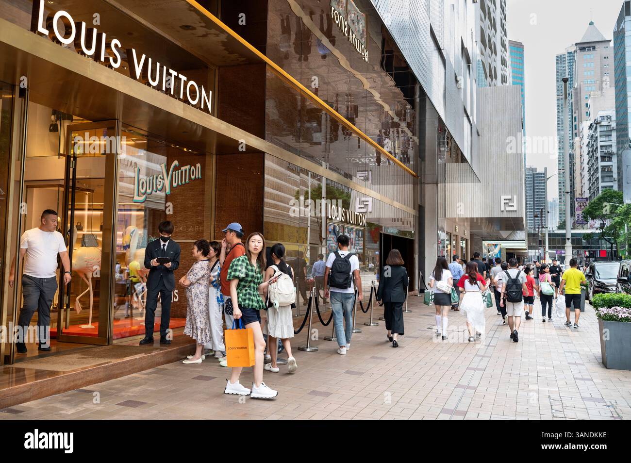 Shoppers queue up as they wait to enter the French luxury fashion brand ...