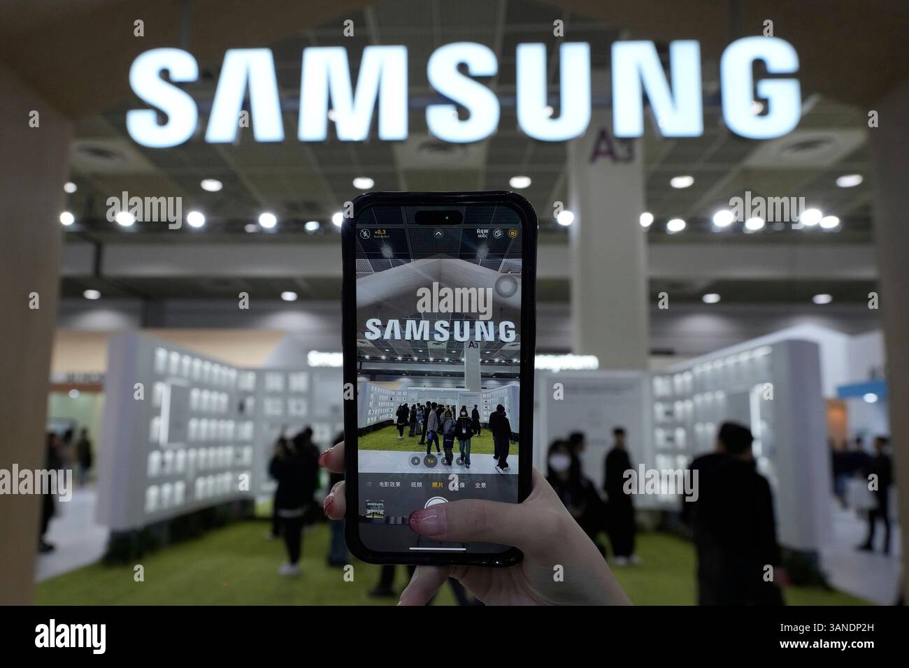 FILE - A visitor takes a picture of the logo of Samsung Electronics at ...