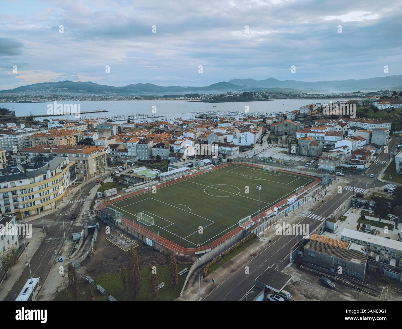 Aerial view of a beautiful coastal cityscape featuring a football pitch ...