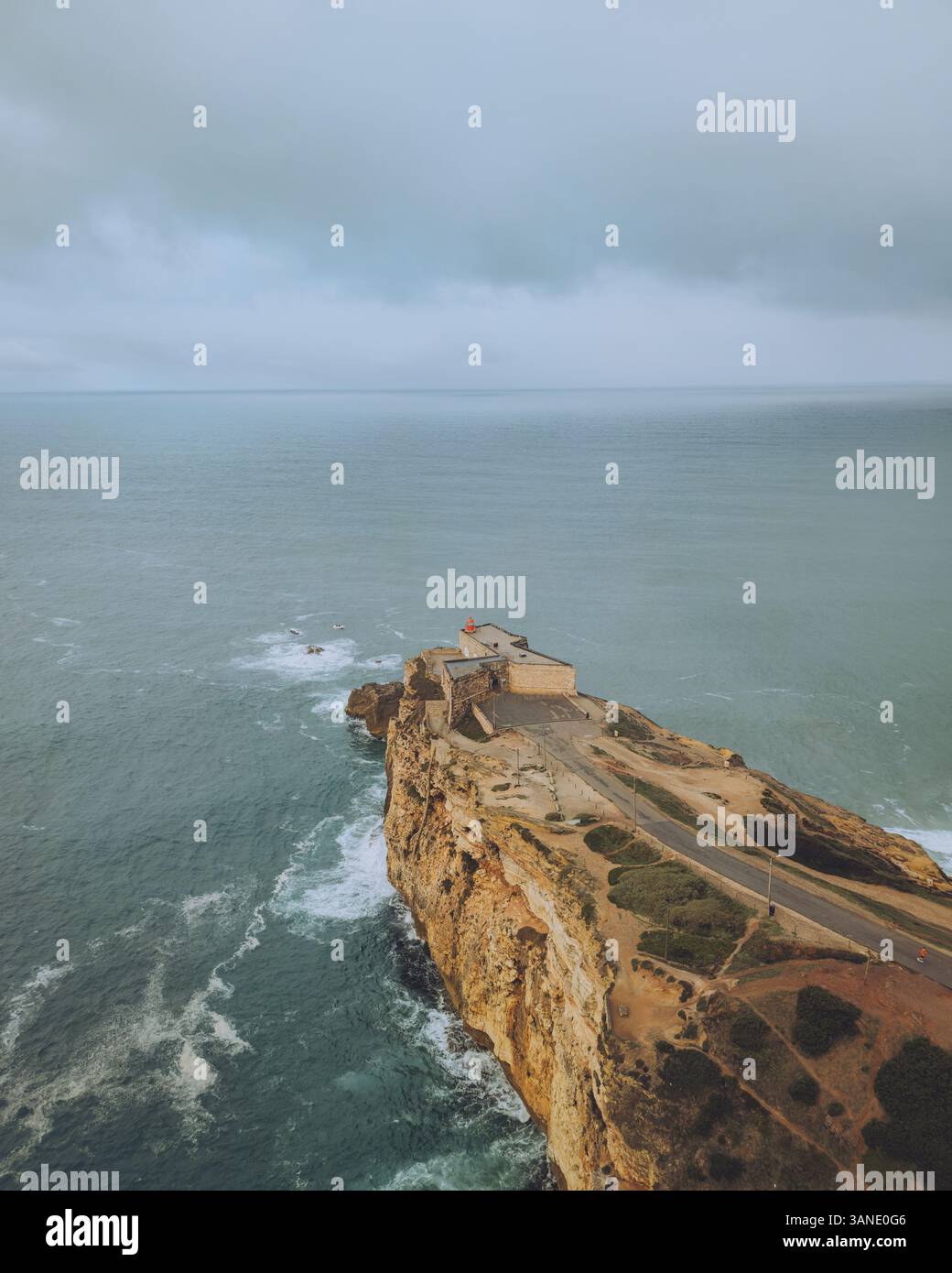 Aerial view of dramatic cliffs and a lighthouse overlooking the ocean ...