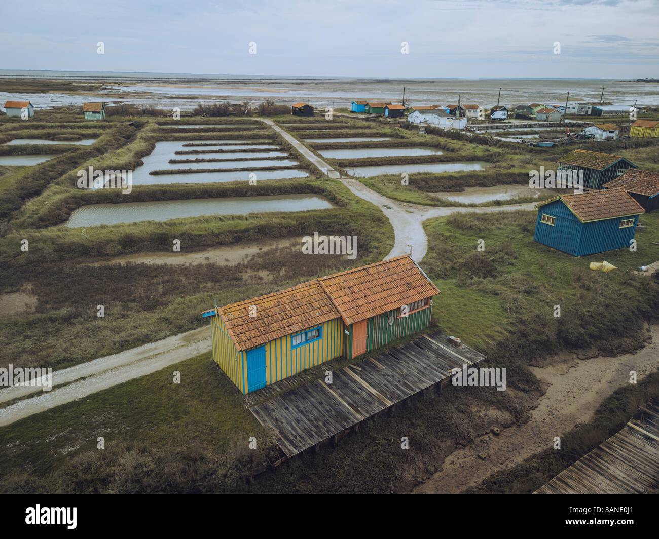 Aerial view of oyster huts and ponds along a serene shoreline, Les ...