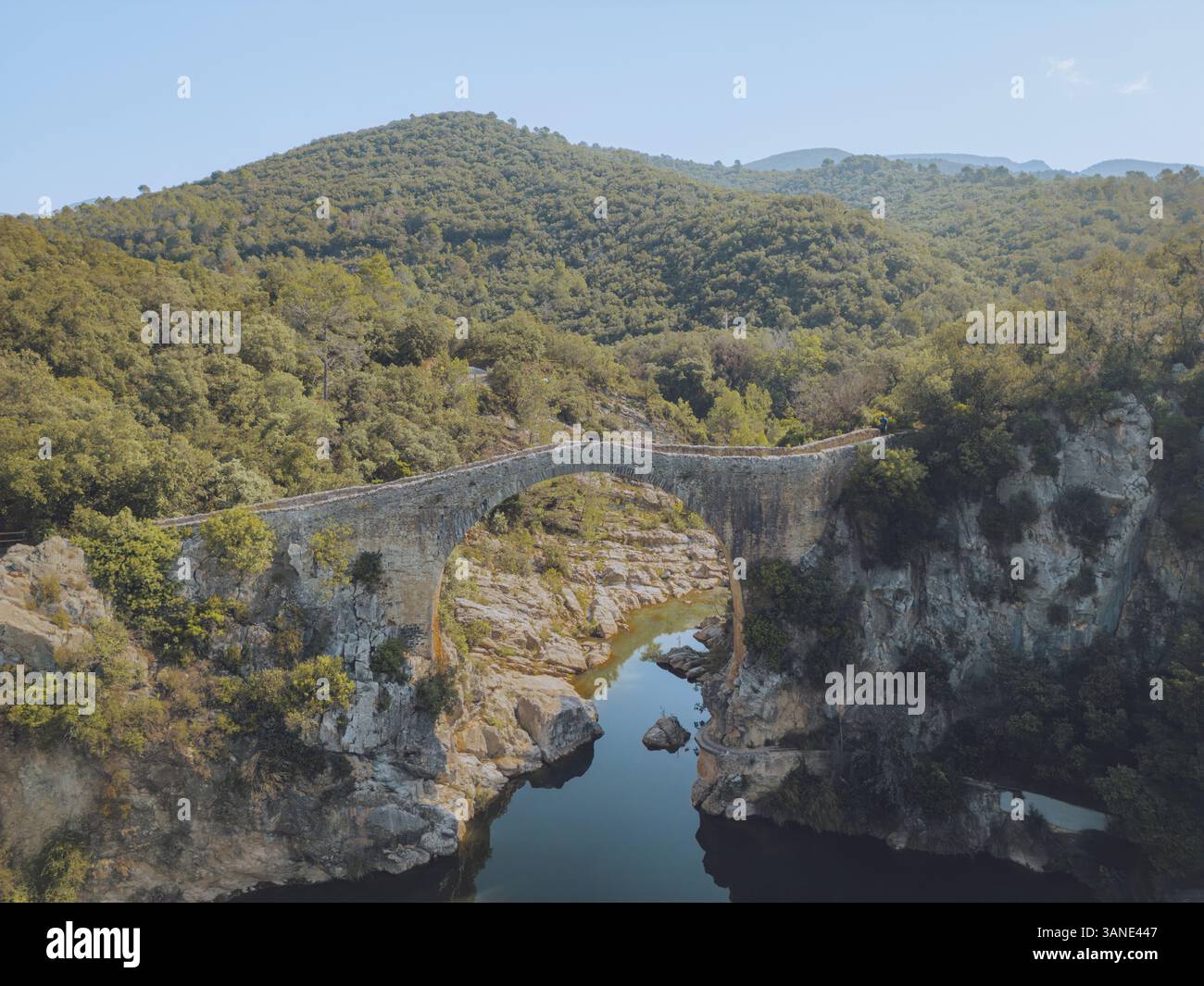 Aerial view of the historic stone Bridge of Llierca over a tranquil ...