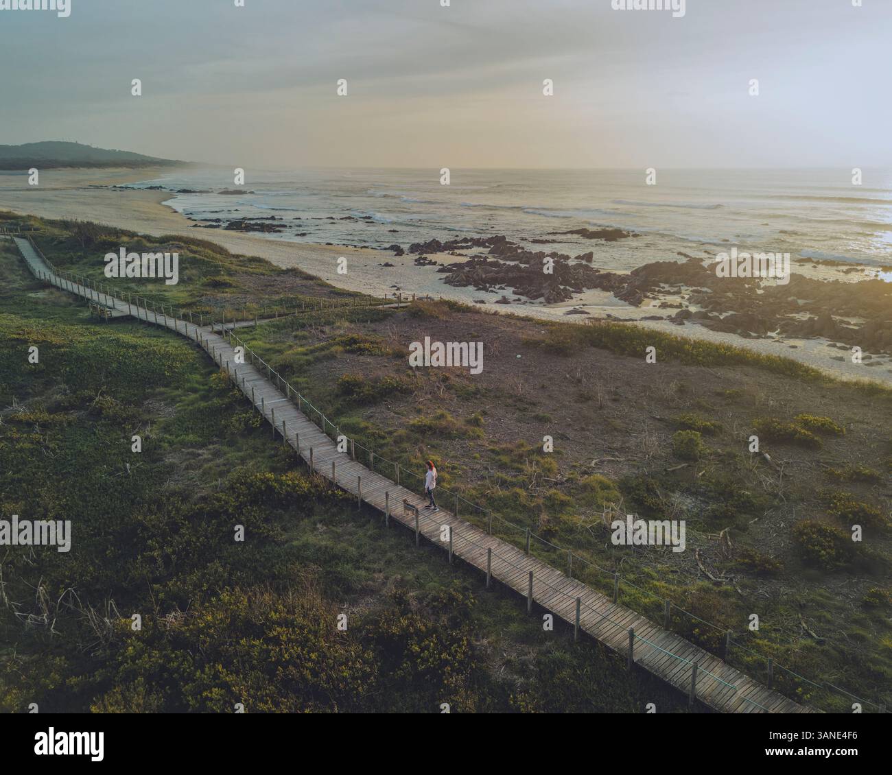Aerial view of Praia da Duna do Caldeirao at dusk with rocky shore and ...