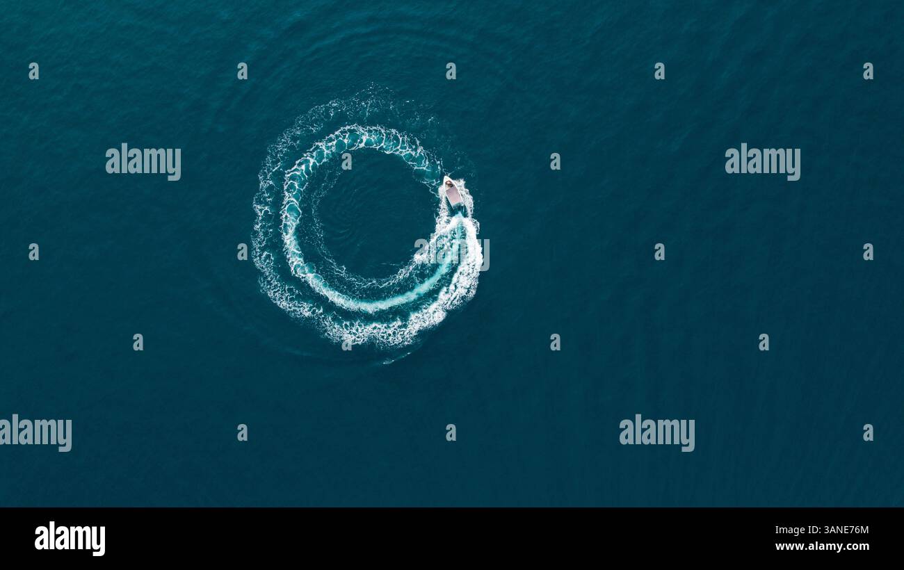 Aerial view of a boat driving in circle in the sea Stock Photo - Alamy