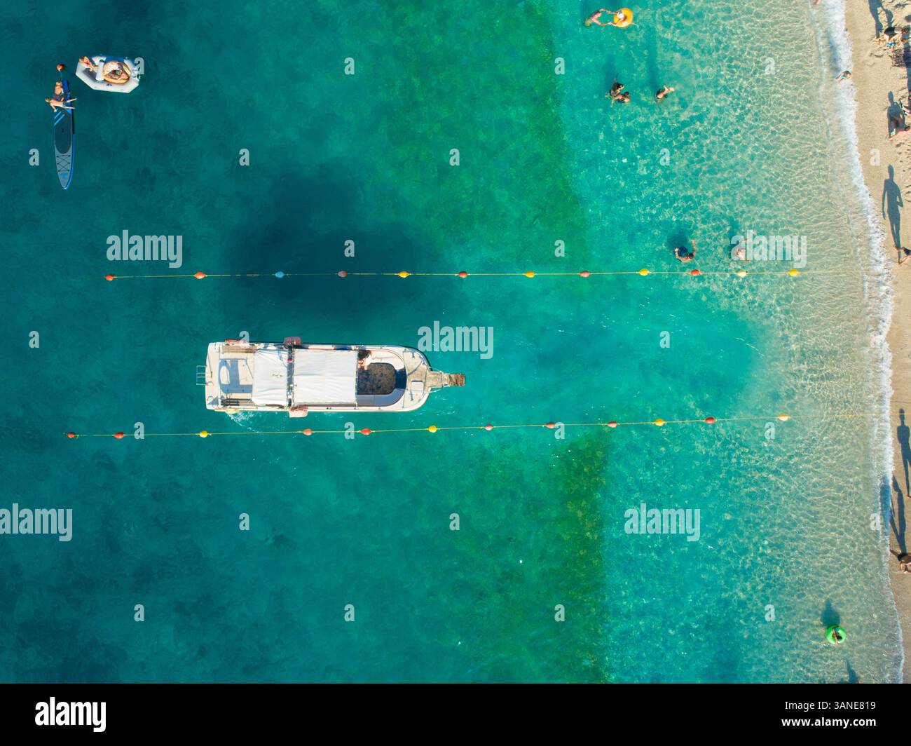 Aerial view of passenger boat entering buoy line on beach coast of ...