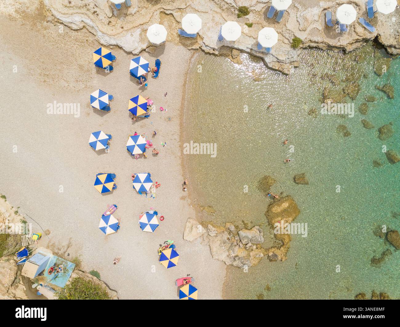 Aerial view of blue and white parasols on the shore of Rhodes island ...