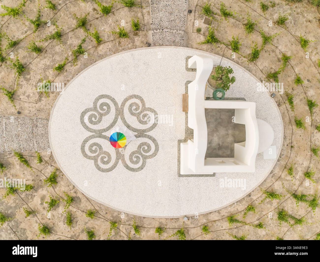 Aerial view of woman in wedding dress holding rainbow umbrella on ...